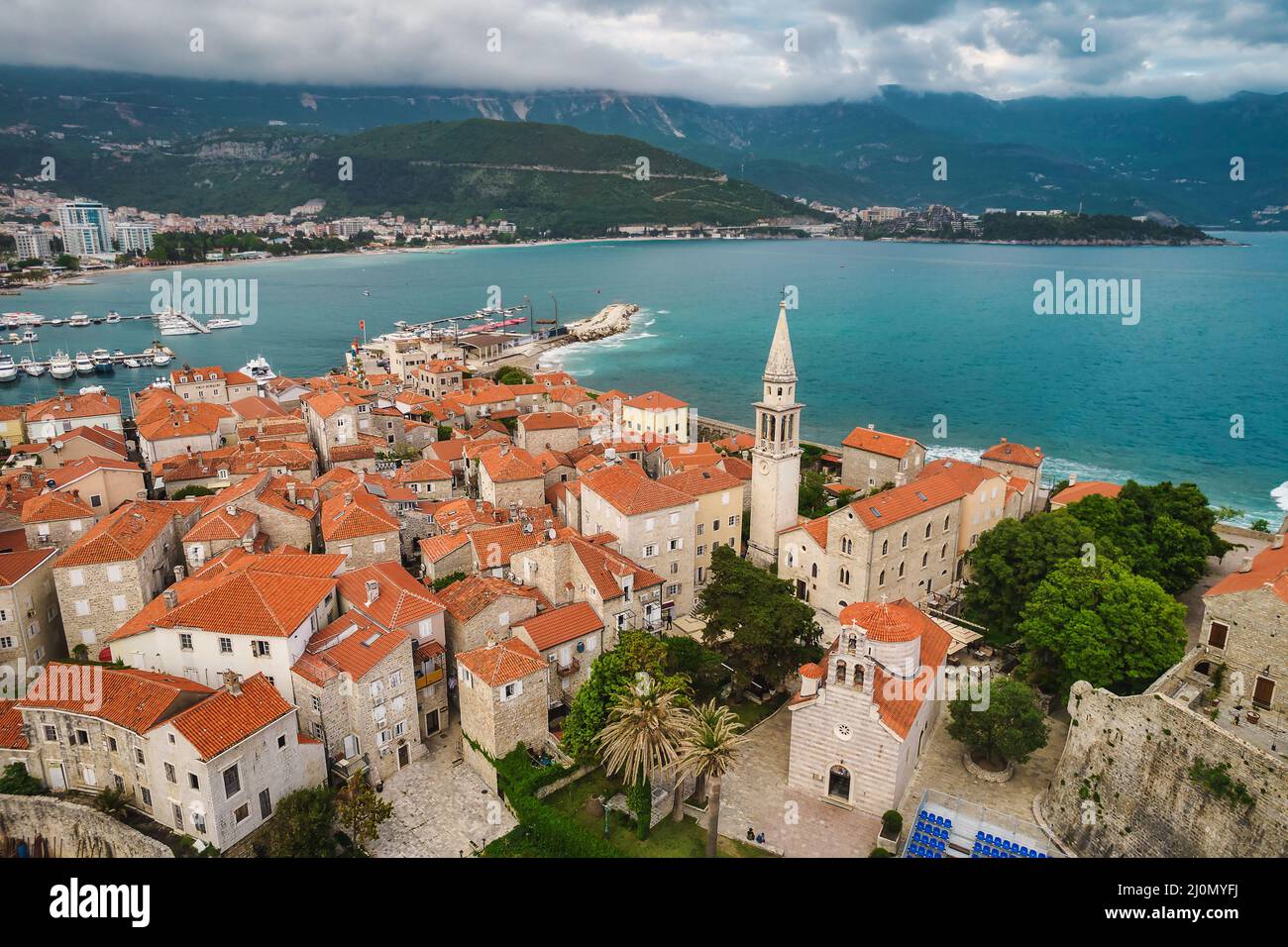 Aerial view of Budva old town with mighty sea waves, famous touristic ...