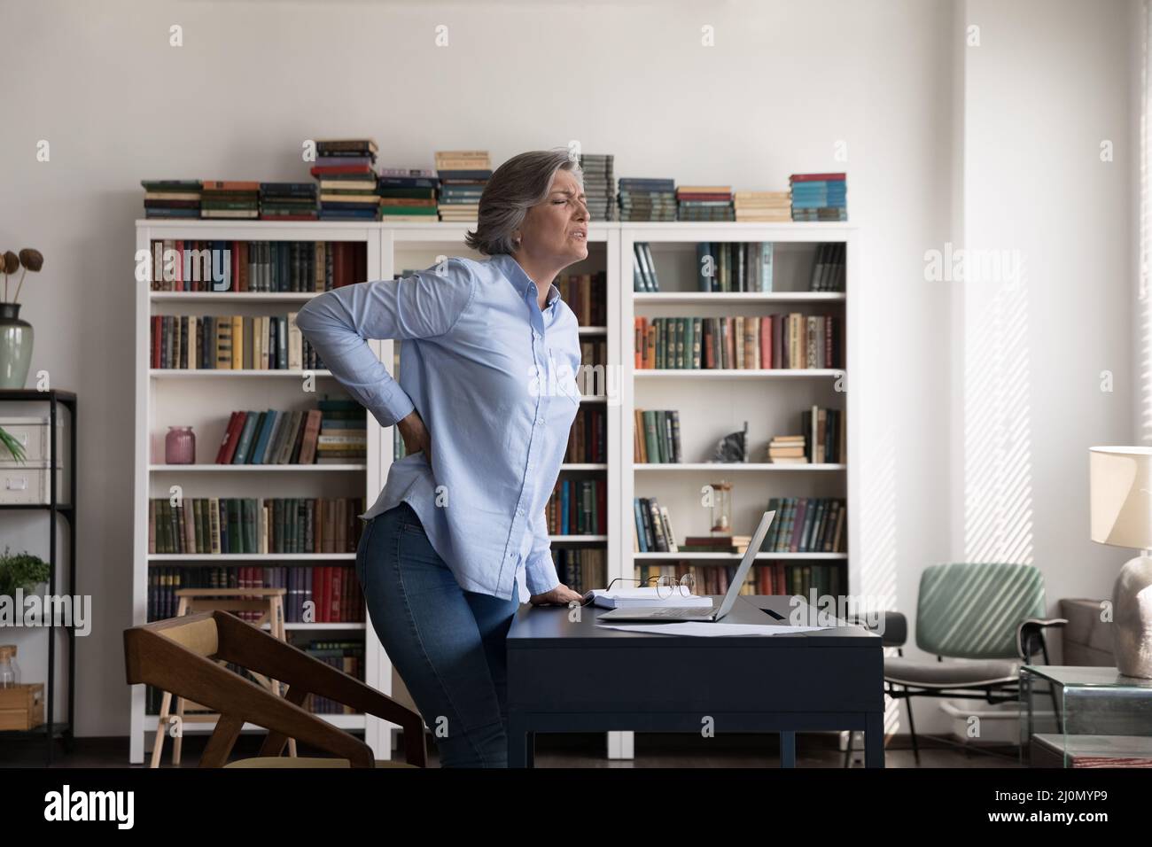 Older businesswoman touch back muscles, suffer from sudden pain Stock ...