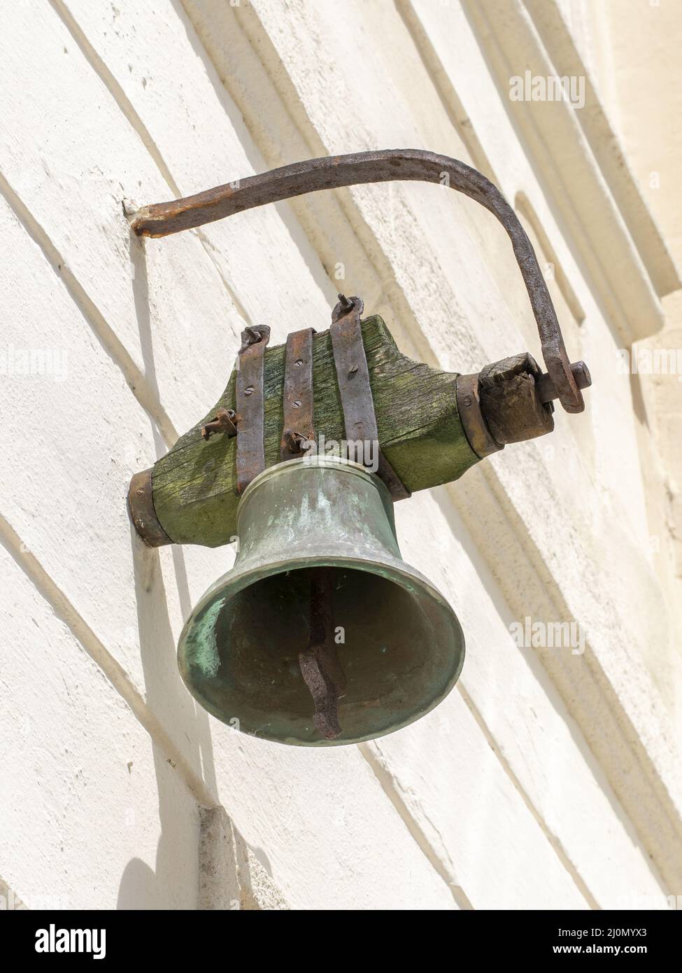 An antique old metal vintage bell mounted on the wall Stock Photo - Alamy