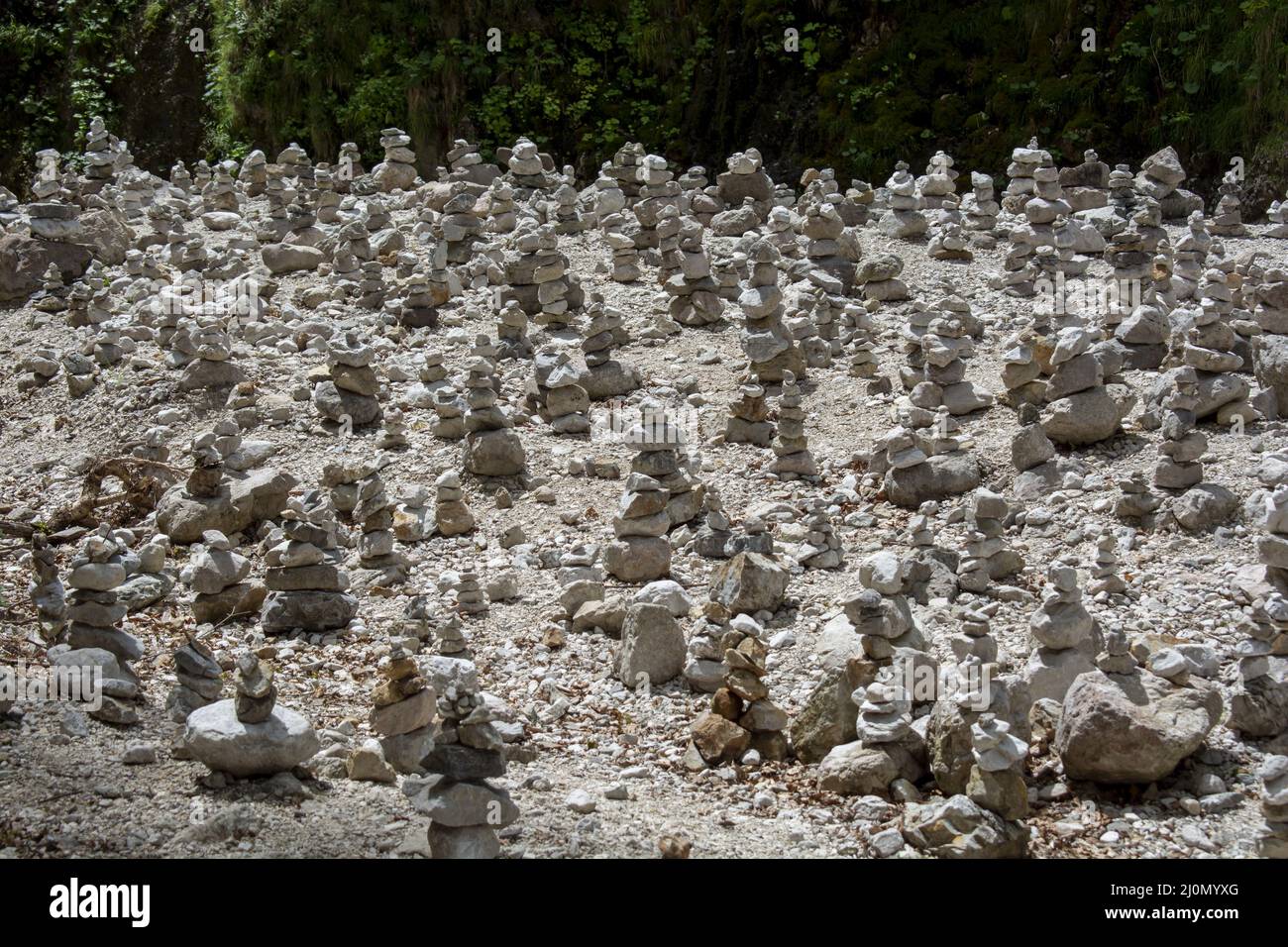 Stone towers and piles of stones on a river bank. Stacked rocks forming ...