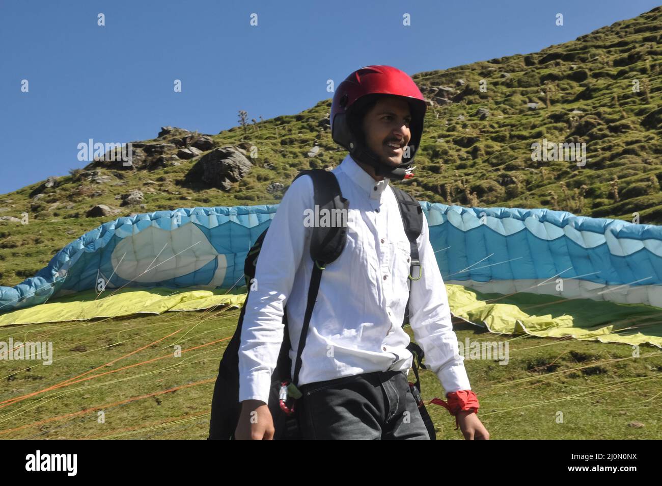 A smiling young man getting ready for paragliding flight Stock Photo ...