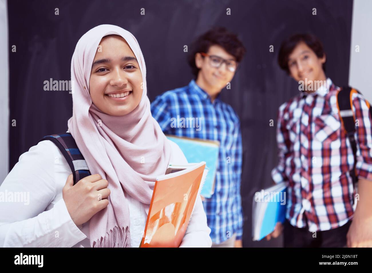 Arabic teenagers, students group portrait against black chalkboard ...