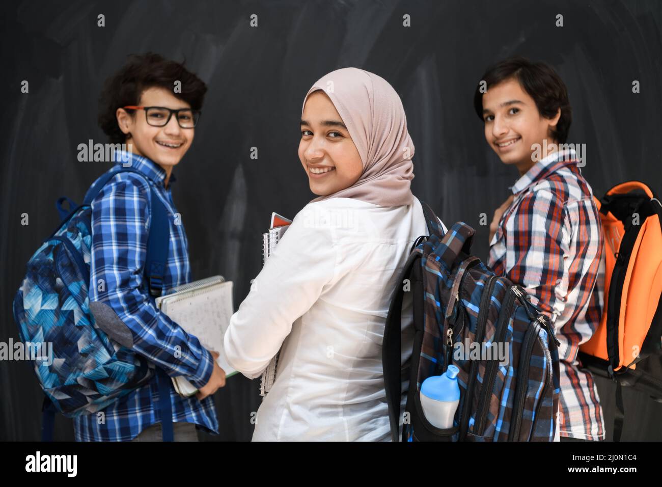 Arabic teenagers, students group portrait against black chalkboard ...