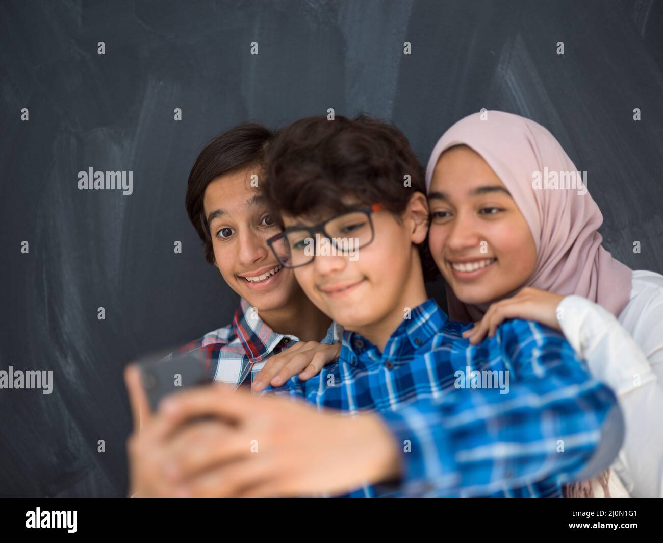 Group of arab teens taking selfie photo on smart phone with black ...