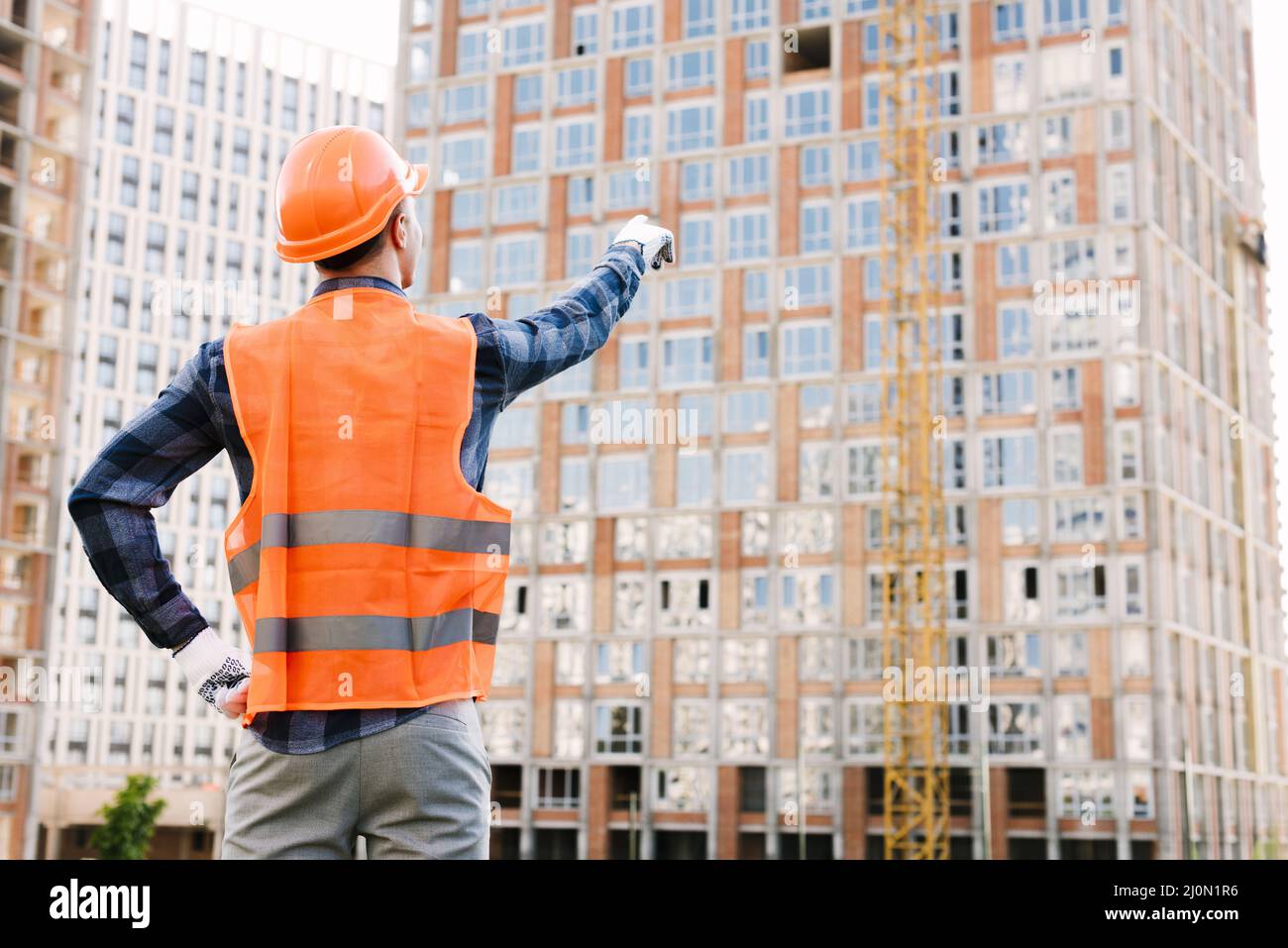 Back view man pointing building Stock Photo - Alamy