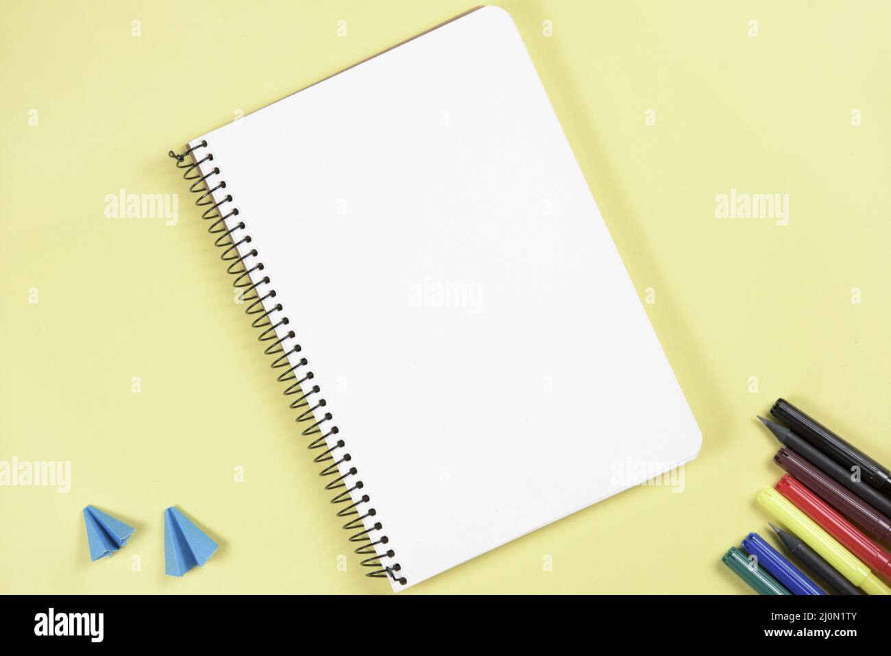 Folded craft paper felt tip pen near blank spiral notepad yellow ...