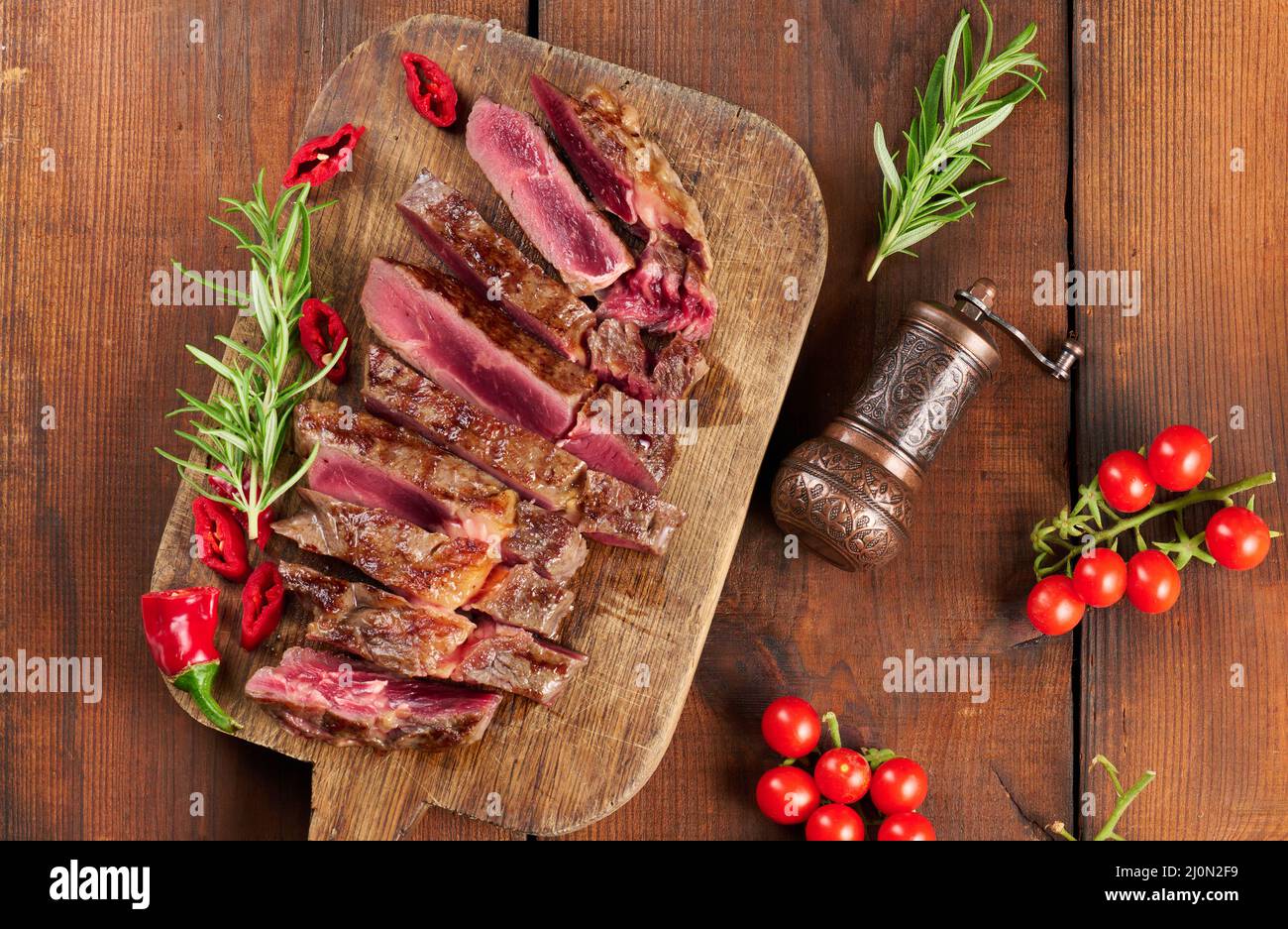 Roasted piece of beef ribeye cut into pieces on a vintage brown ...