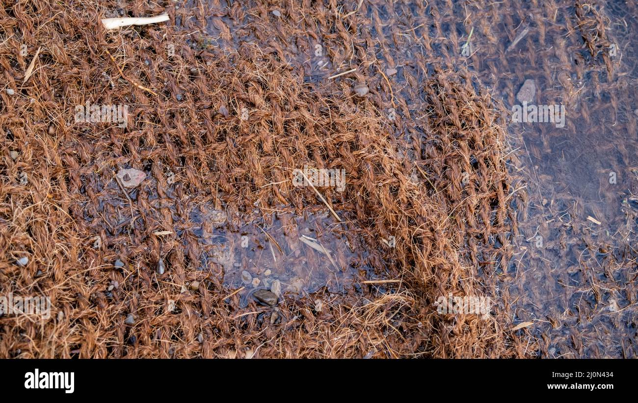 Close up of water flowing over a biodegradable fibre silt sediment net ...