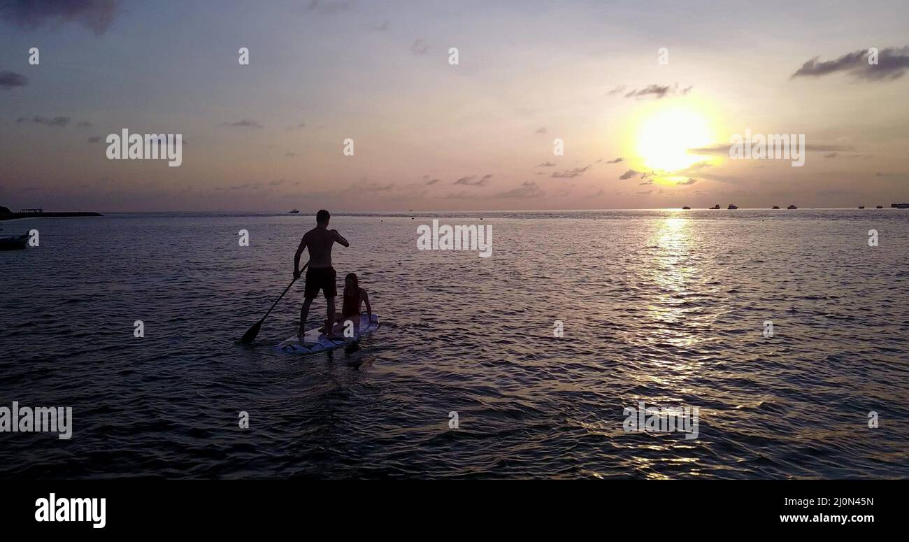 Caucasian couple boarding on a paddleboard in Rasdhoo Island, The ...