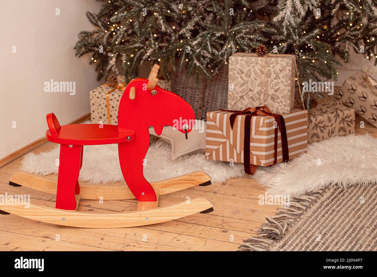 Rocking red horse under festive Christmas tree with gifts Stock Photo ...