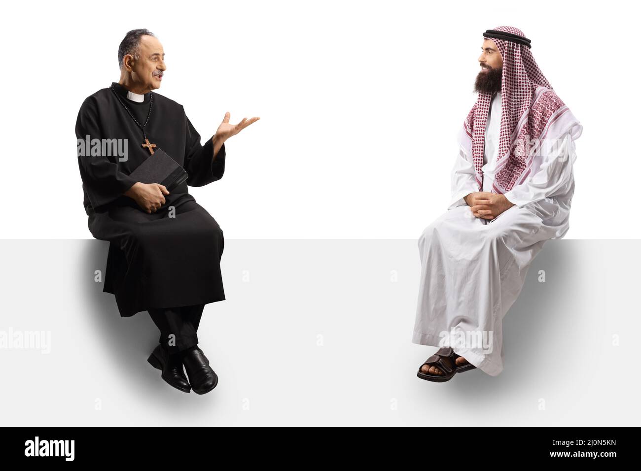 Priest talking to a saudi arab man and sitting on a blank panel ...