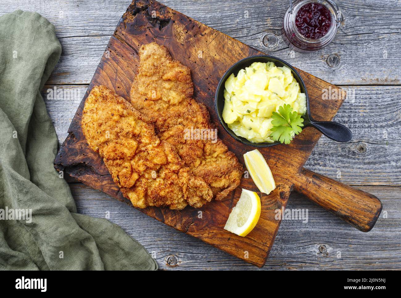 Traditional deep-fried schnitzel with potato salad and cranberries ...