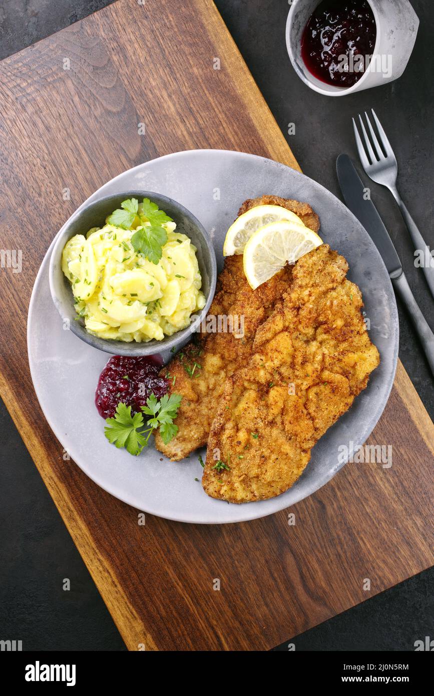 Traditional deep-fried schnitzel with potato salad Stock Photo - Alamy