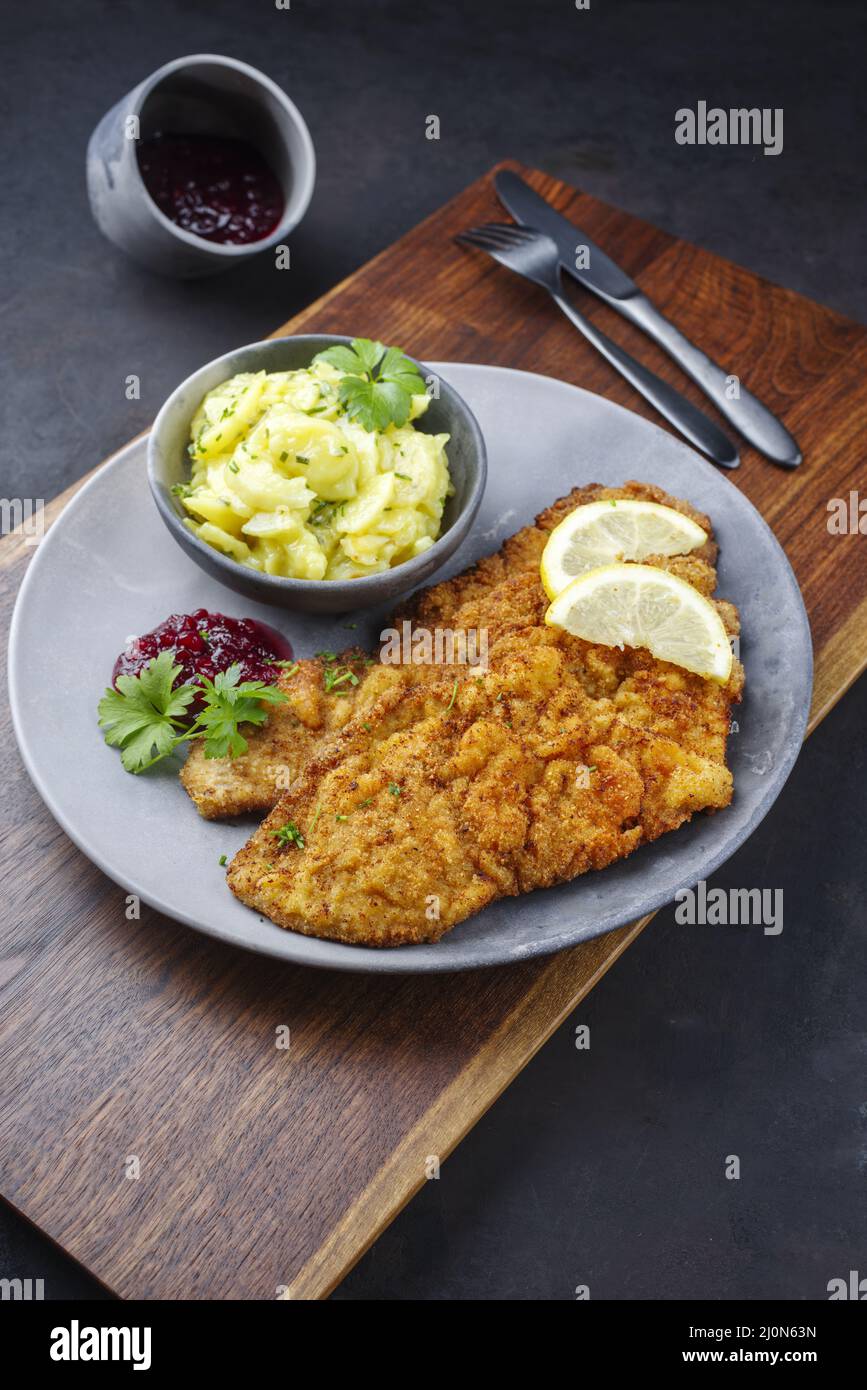 Traditional deep-fried schnitzel with potato salad Stock Photo - Alamy