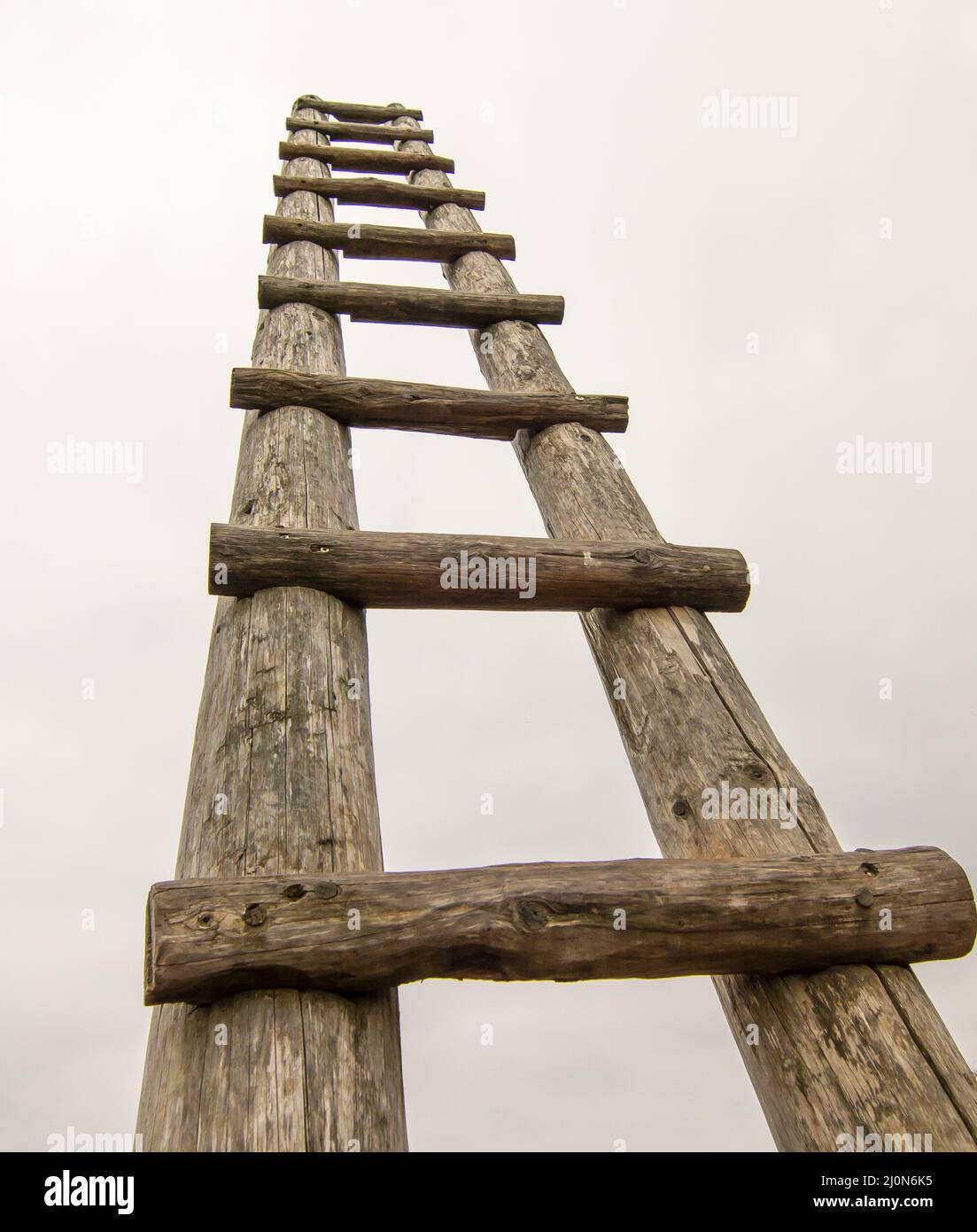 Old wooden ladder on the meadow leading high up in the sky . Ladder to ...