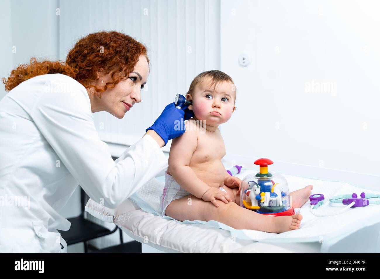 Little girl at doctor for checkup. Doctor pediatrician and baby patient ...