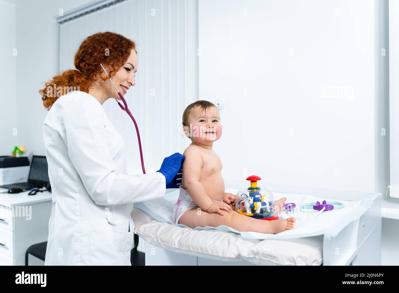 Pediatrician providing healthcare for her baby patient in the office of ...