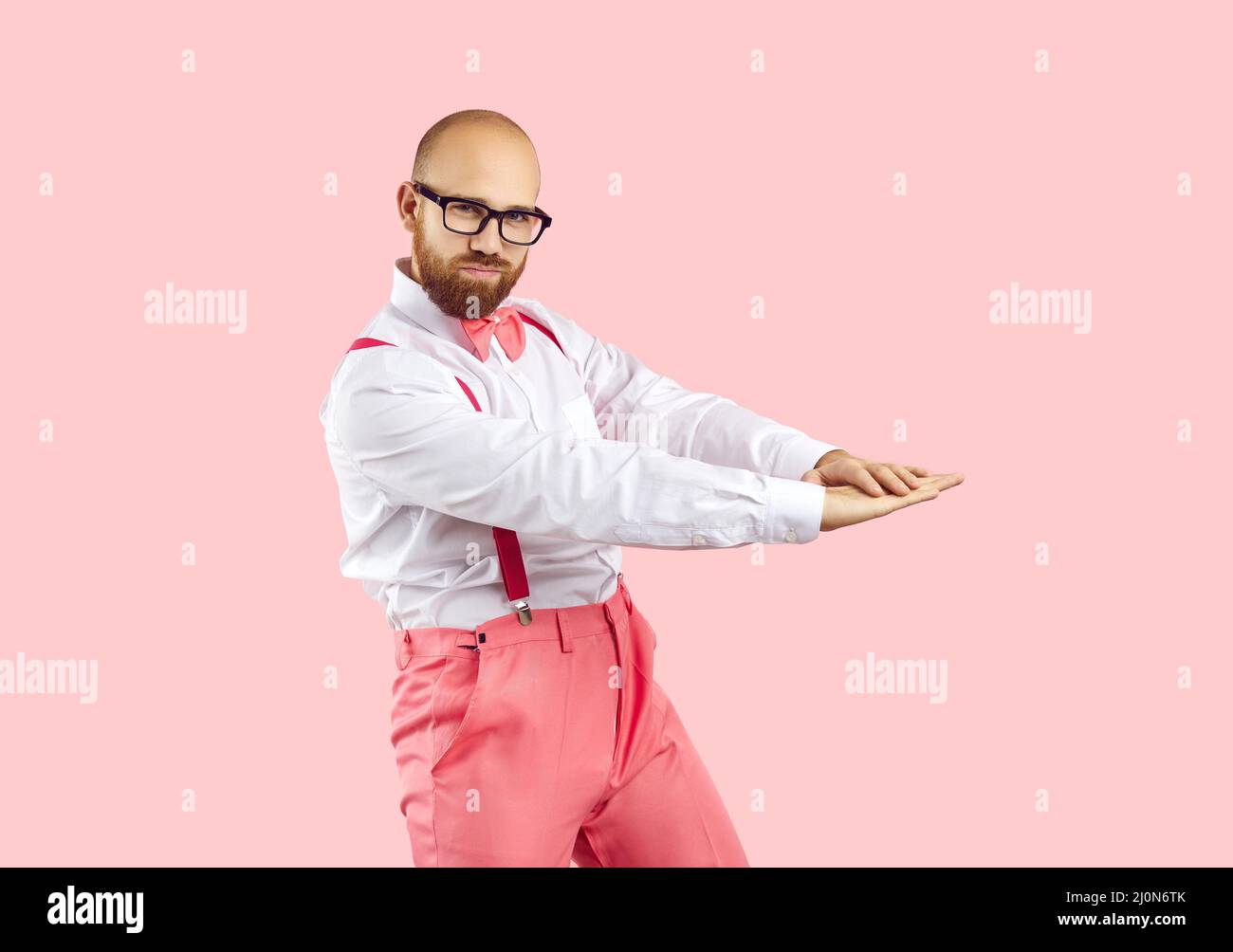 Portrait of a handsome dancer in glasses dancing isolated on a pink ...