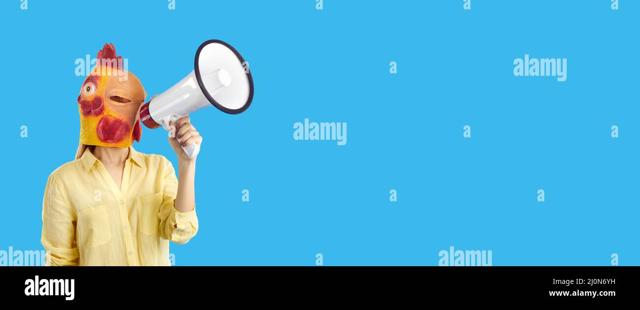 Woman in funny chicken mask making announcement with megaphone on copy ...