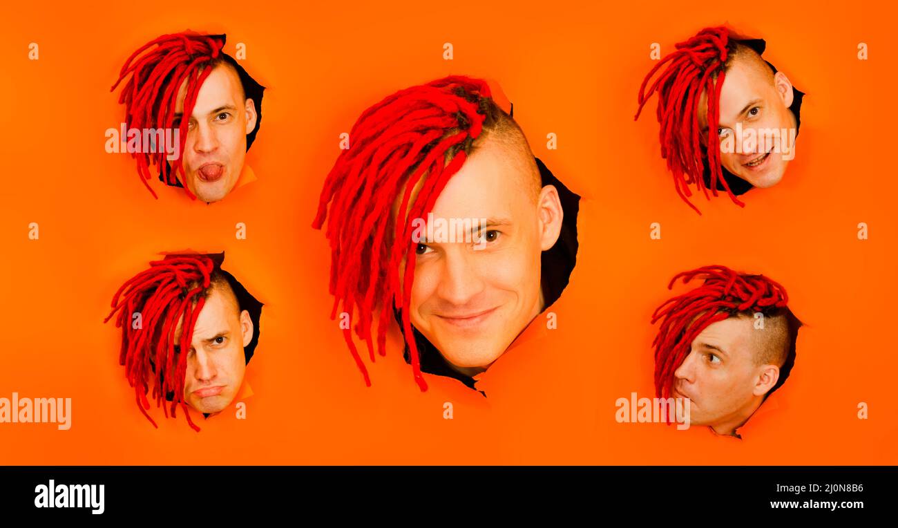 Funny male with red dreadlocks peeking through torn orange paper ...