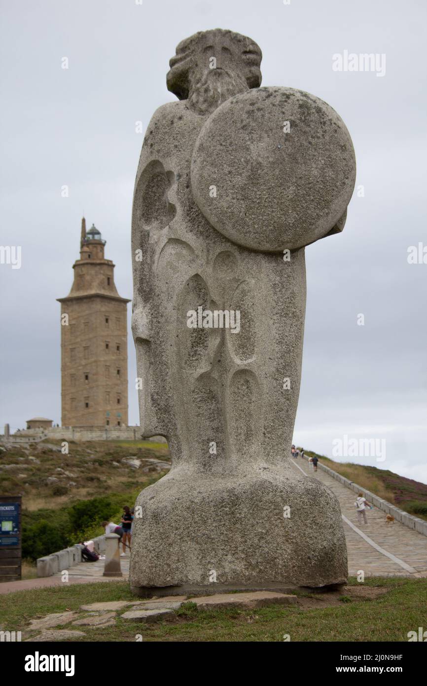 Vertical shot of the Breogan statue with the Hercules Tower in the ...