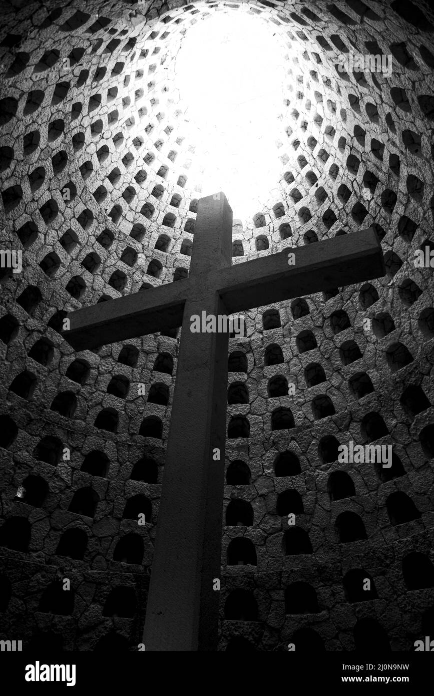 Vertical shot of an underground cross in the Crypt of Sighs surrounded ...