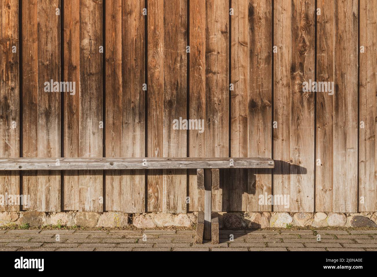 Wooden bench against wooden wall Stock Photo - Alamy