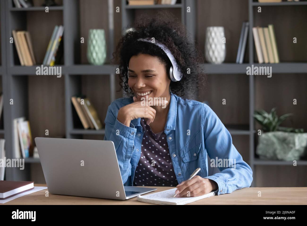 Happy student girl in wireless headphones making video call Stock Photo ...