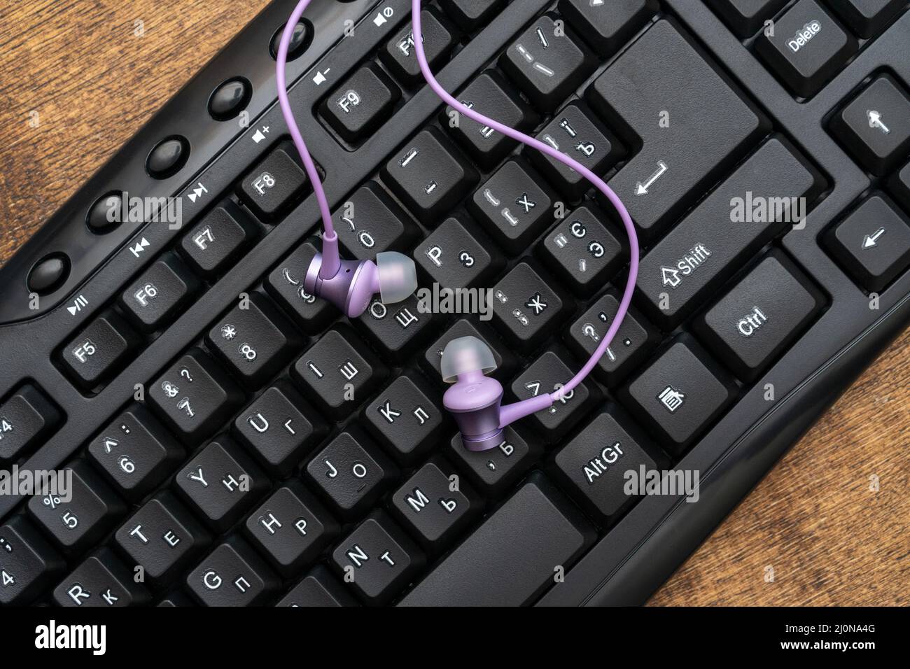 Computer keyboard and earphones Stock Photo - Alamy