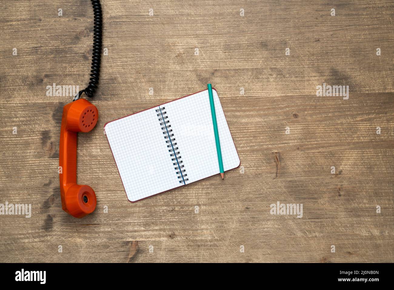 Orange telephone receiver and blank notebook Stock Photo - Alamy
