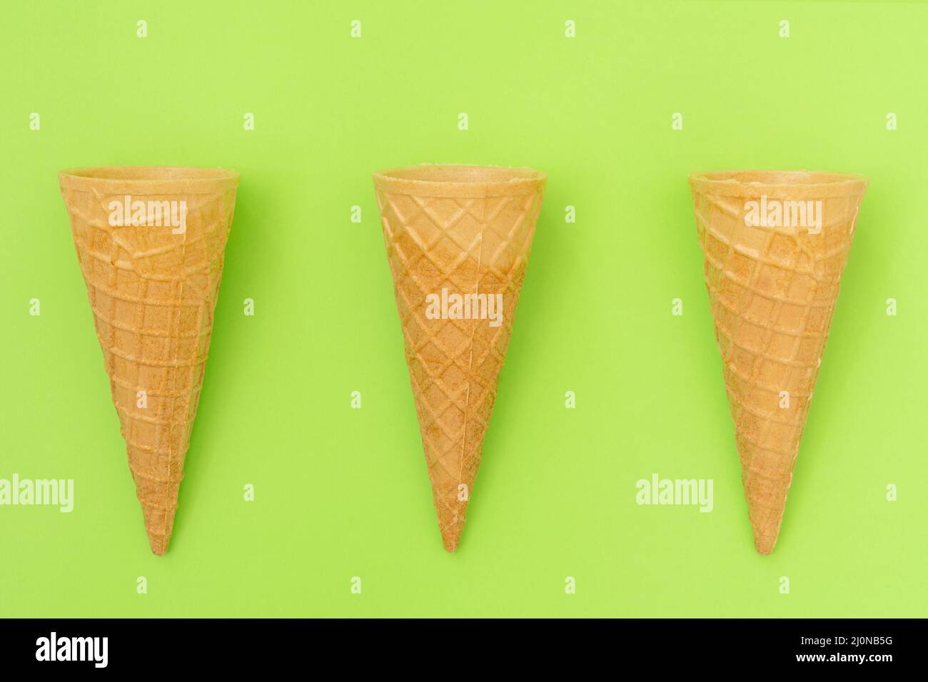 Three wafer cones on green background Stock Photo - Alamy