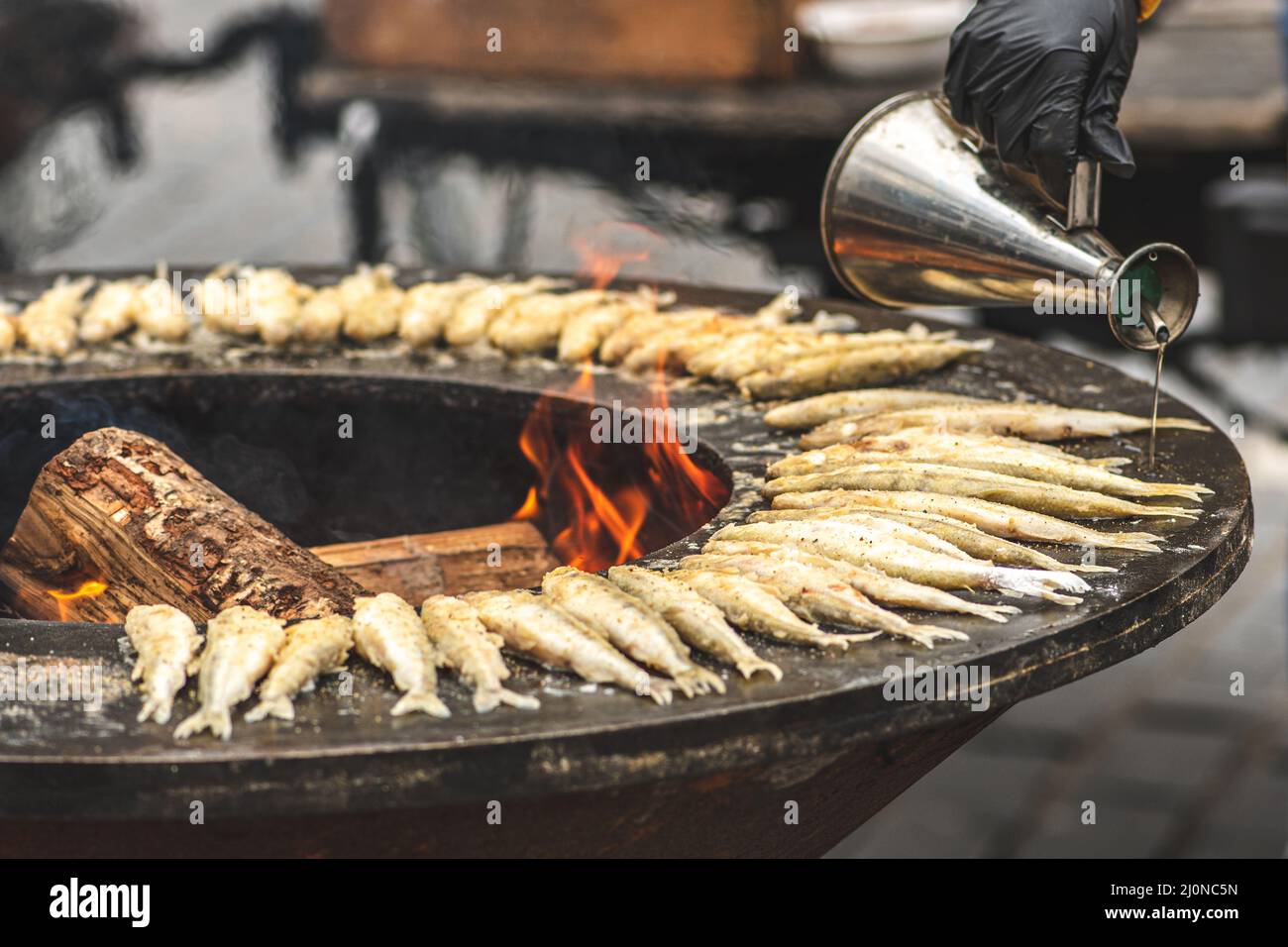 Preparing traditional tasty fried European smelt fish being cooked on ...