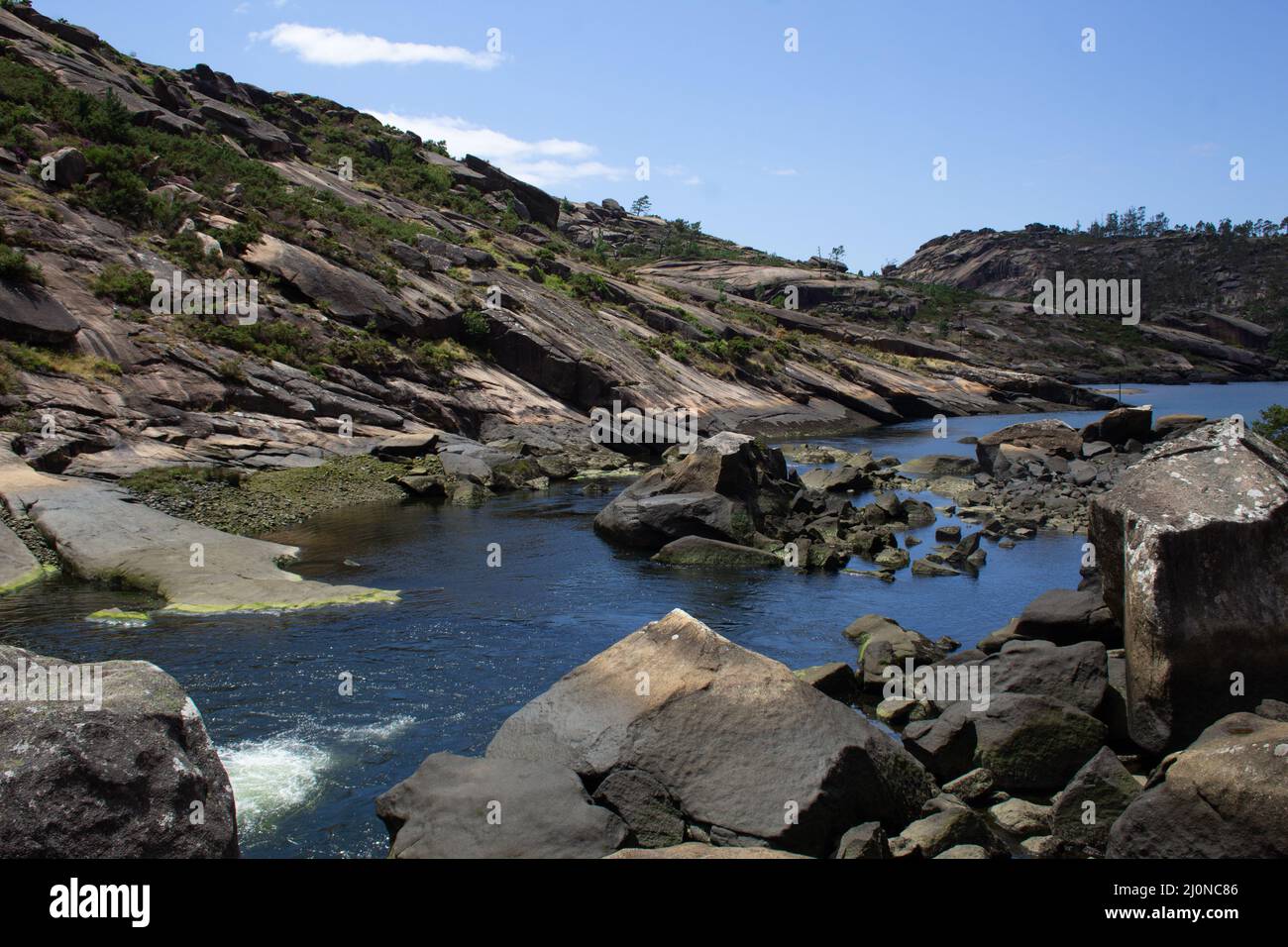 Closeup shot of the Ezaro waterfall flowing into the river in Galicia ...