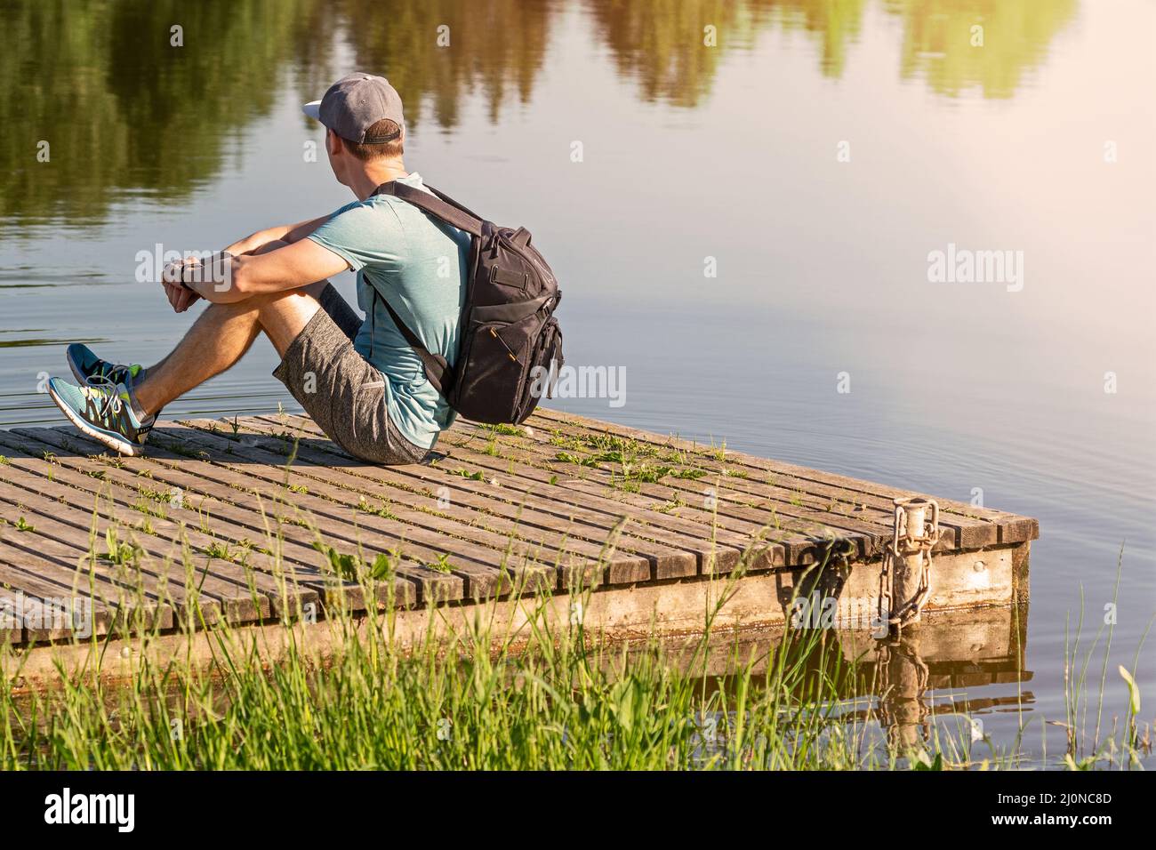 Man sitting boardwalk hi-res stock photography and images - Alamy