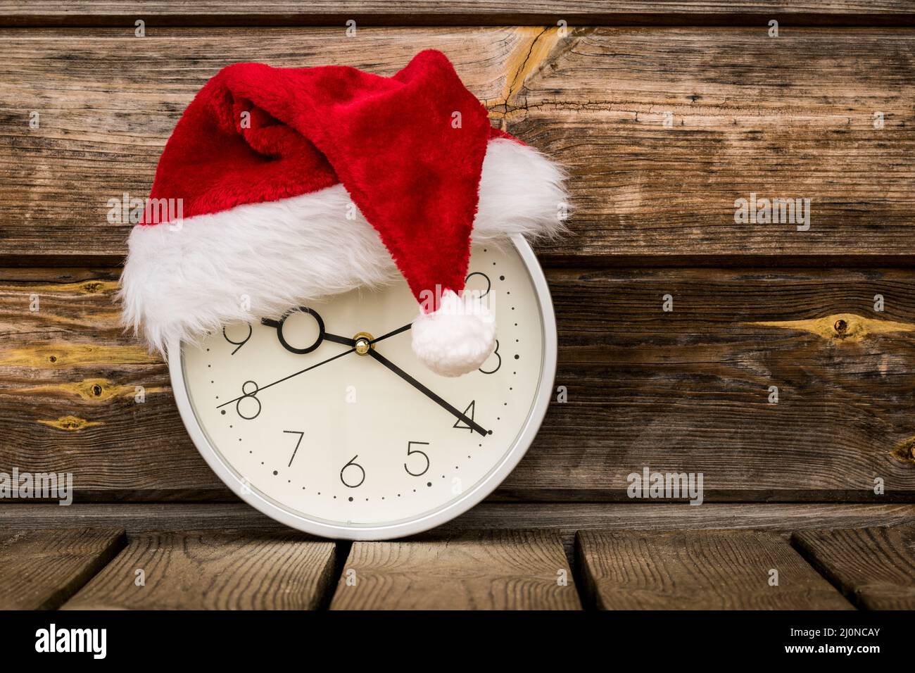 Christmas time - wall clock with Santa hat Stock Photo - Alamy