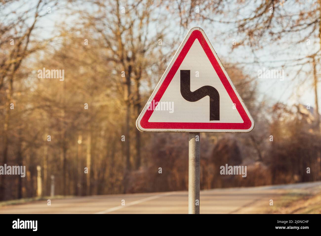 Curved road traffic sign Stock Photo - Alamy