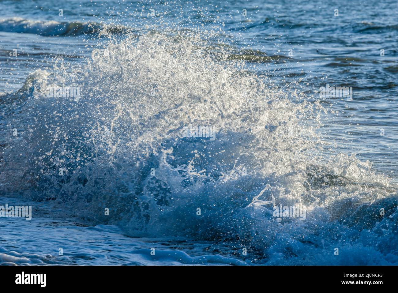 Waves splashing at sunrise Stock Photo - Alamy