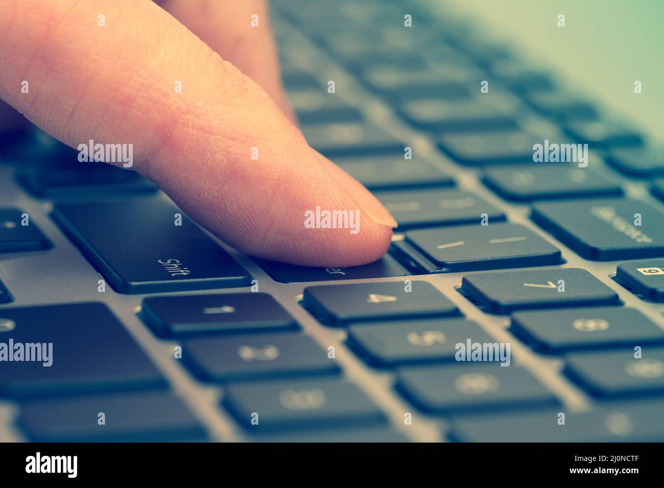 Finger pressing on computer keyboard Stock Photo - Alamy