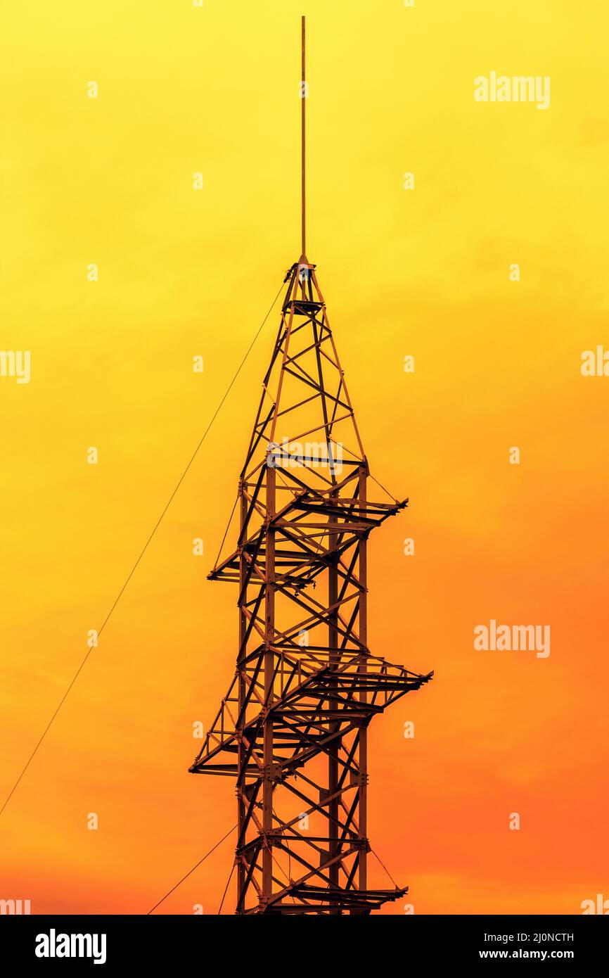 Electricity pylon at orange sunset Stock Photo - Alamy
