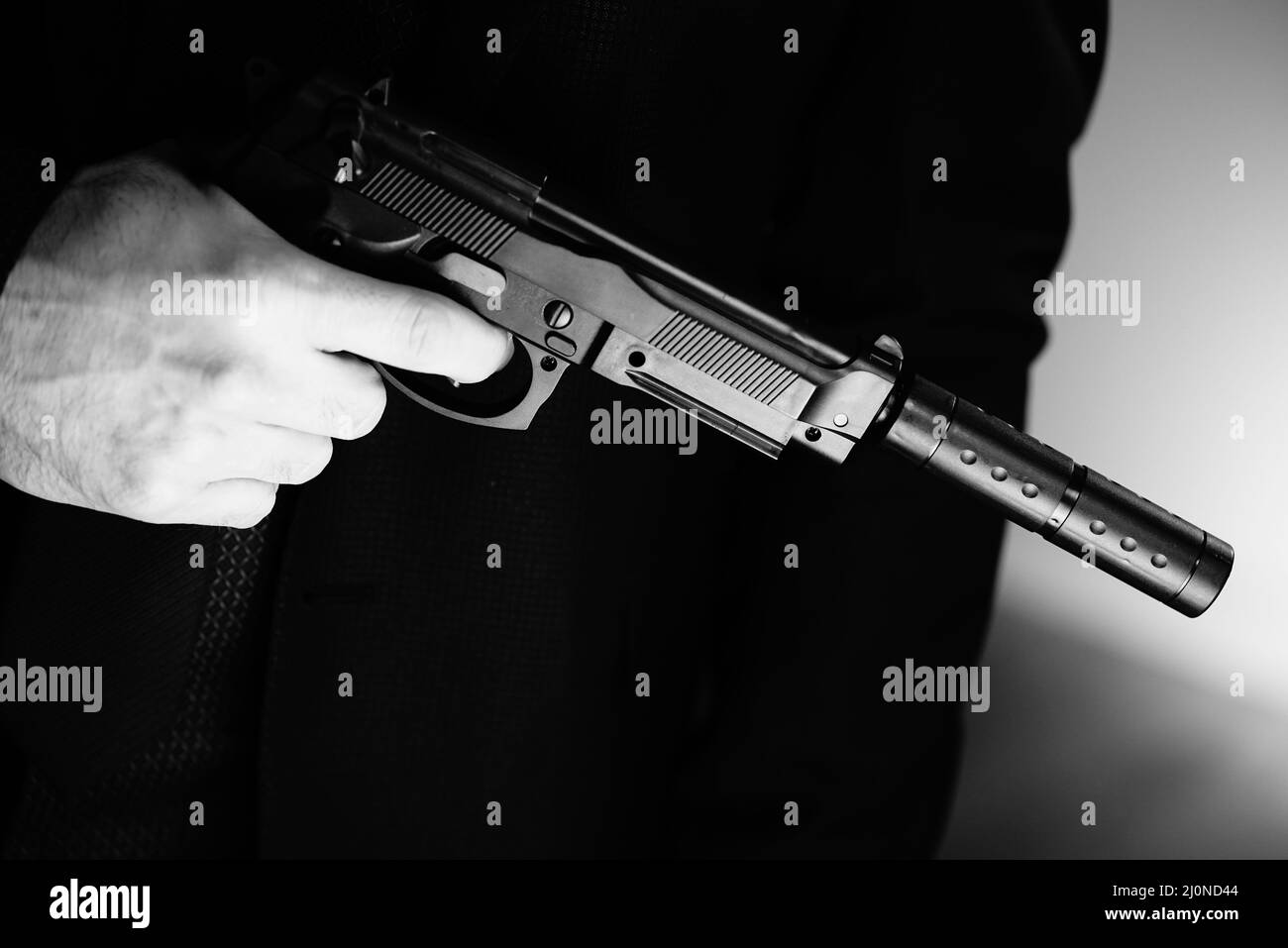 Elegant man holding gun Stock Photo - Alamy