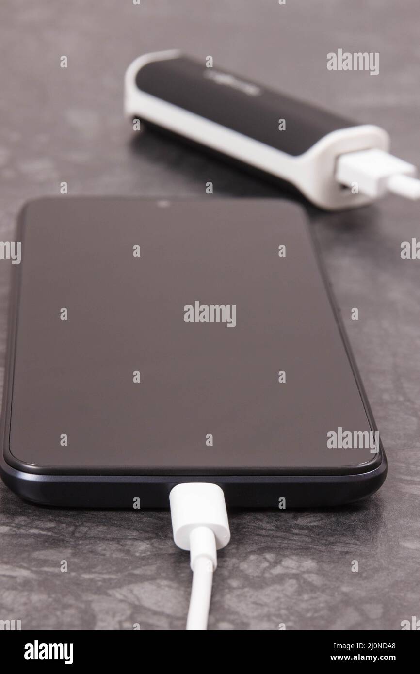 External black powerbank charging empty battery of smartphone or mobile ...