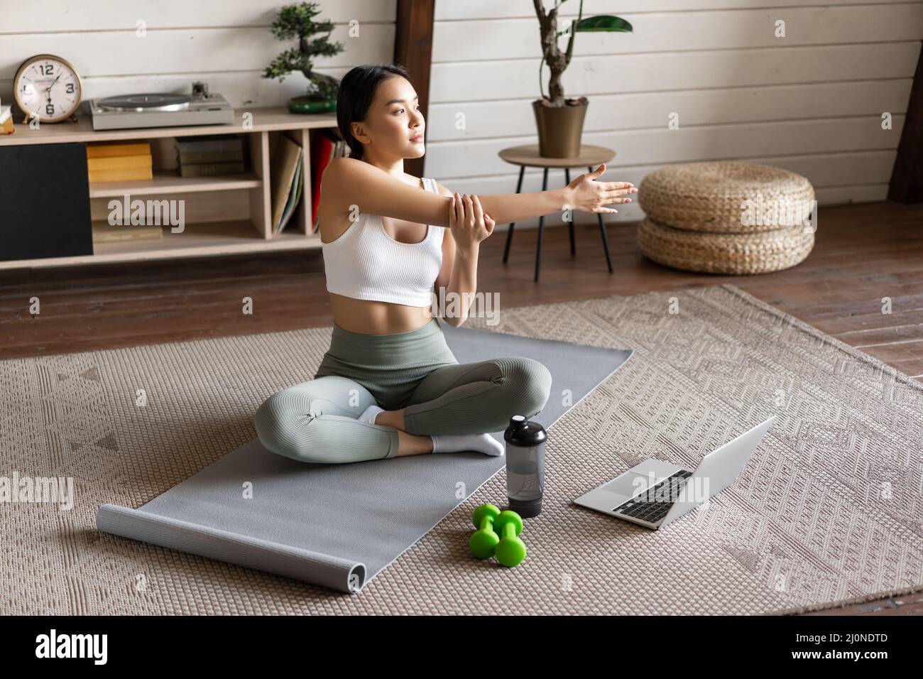 Young asian fitness girl doing stretching, sport workout at home ...