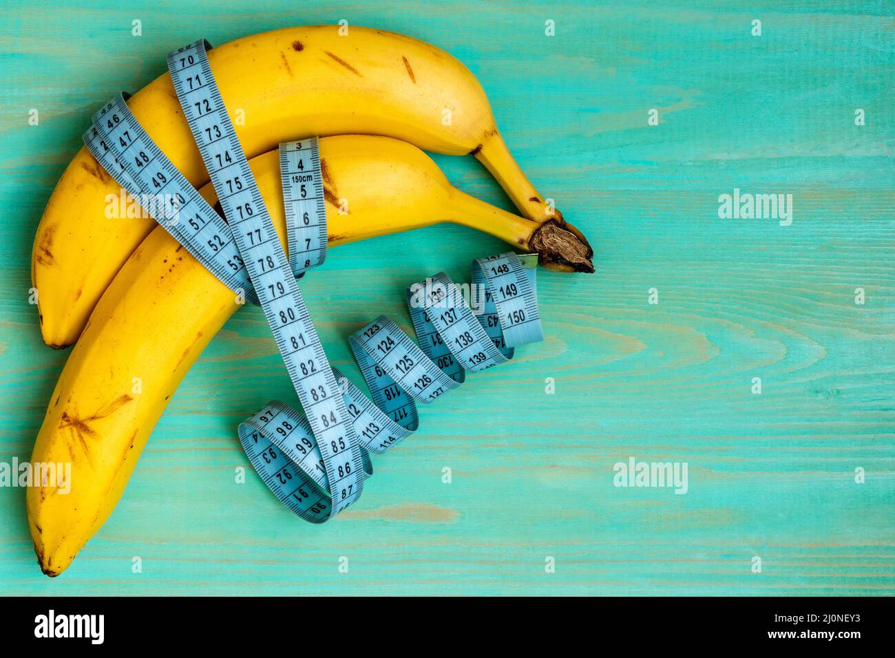 Bananas and blue measuring tape Stock Photo - Alamy