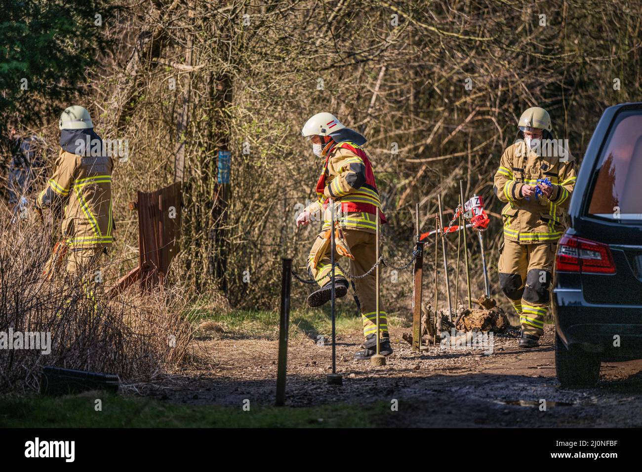 Bremen, Germany. 20th Mar, 2022. Firefighters walk past a hearse to the ...