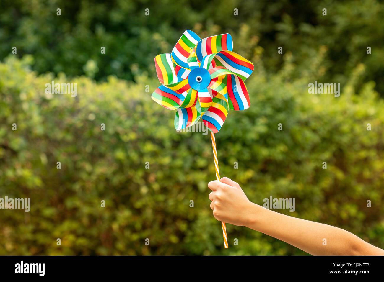 Child holding colorful pinwheel Stock Photo - Alamy
