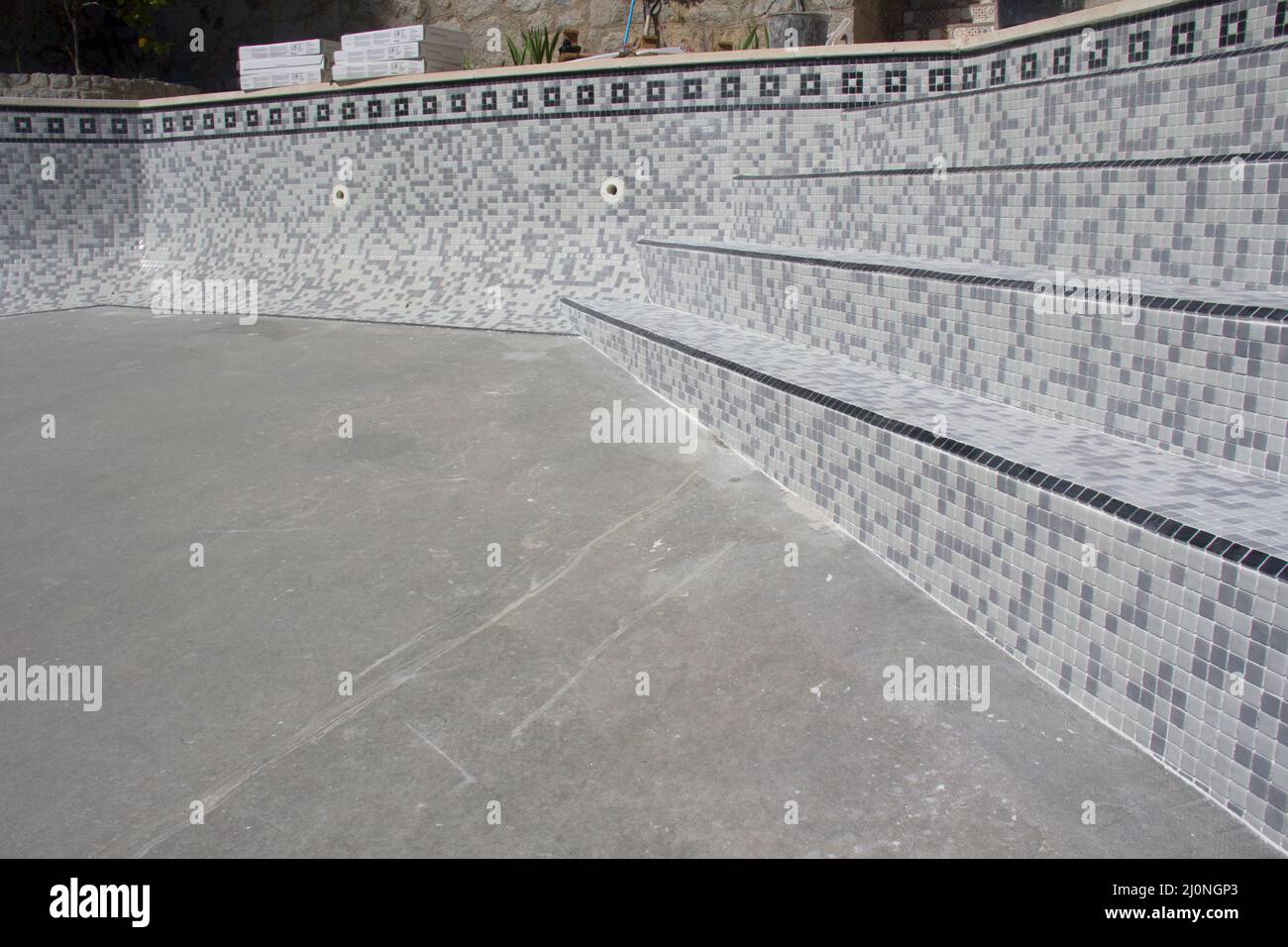 Tiles being applied to refurbish a swimming pool. image from a group of ...