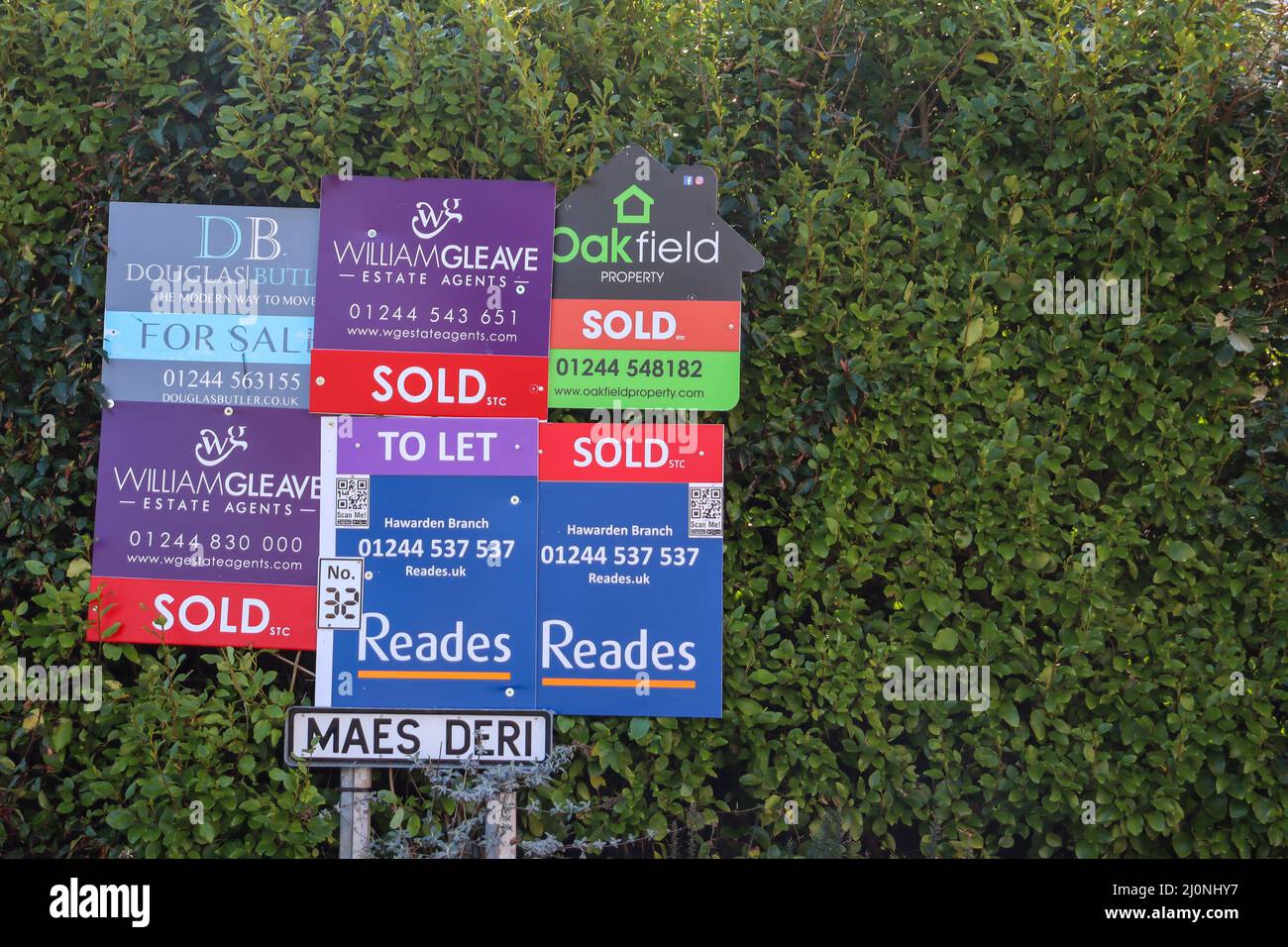 Collection of Estate Agency boards above a road sign Stock Photo - Alamy