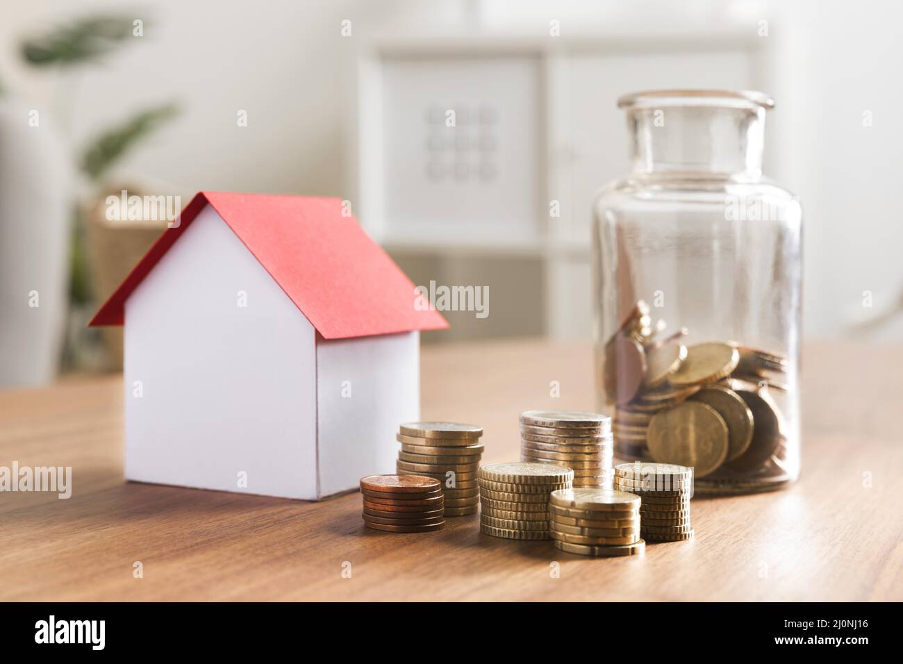 Miniature bank with coins stacks jar beside . High quality and ...