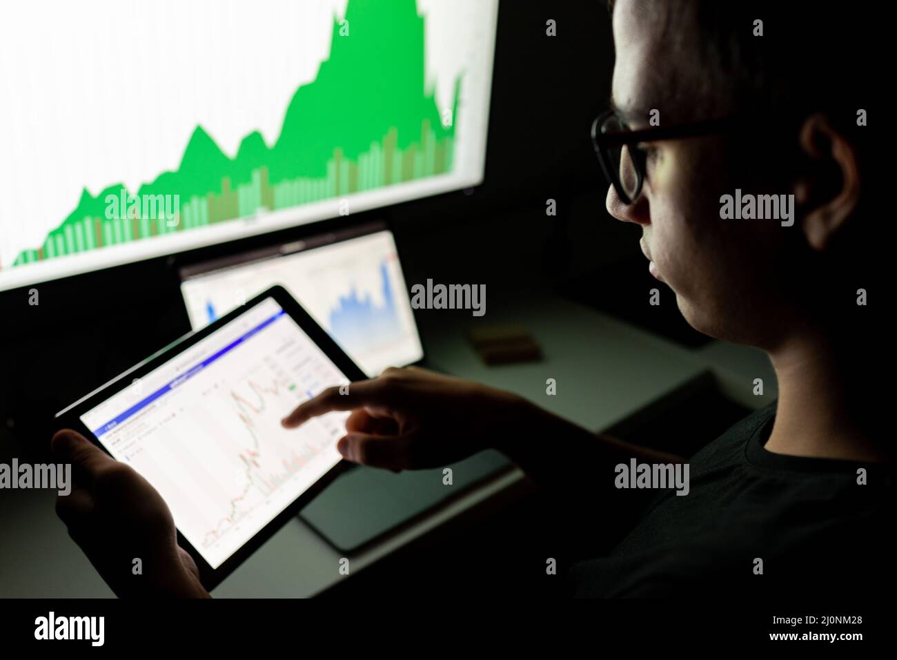 Millenial crypto trader investor analyst looking at computer screen ...