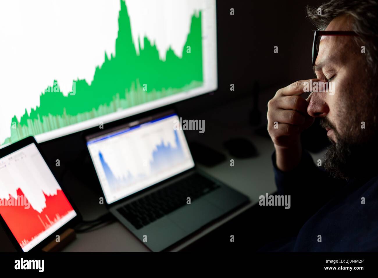 Depressed businessman in front of computer with graph of unsuccessful ...